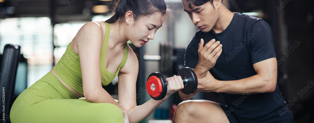 Asian female workout training lifting dumbbell with professional ...