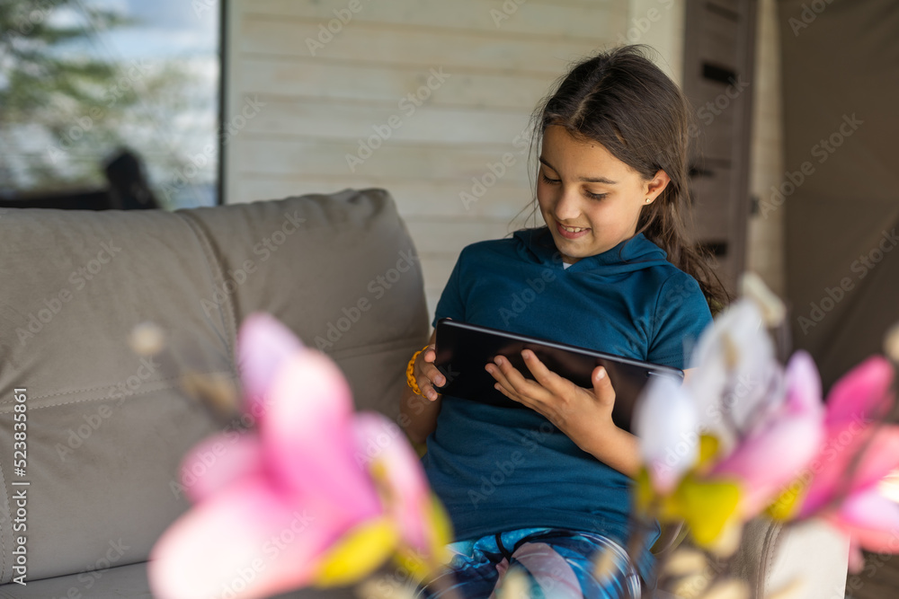 Serious attentive Caucasian Girl use Tablet for watching videos and ...