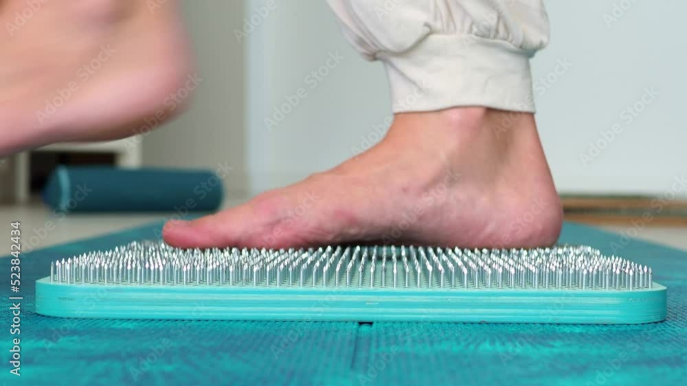 Get off the nails. Sadhu wooden blue board with nails, female feet step ...