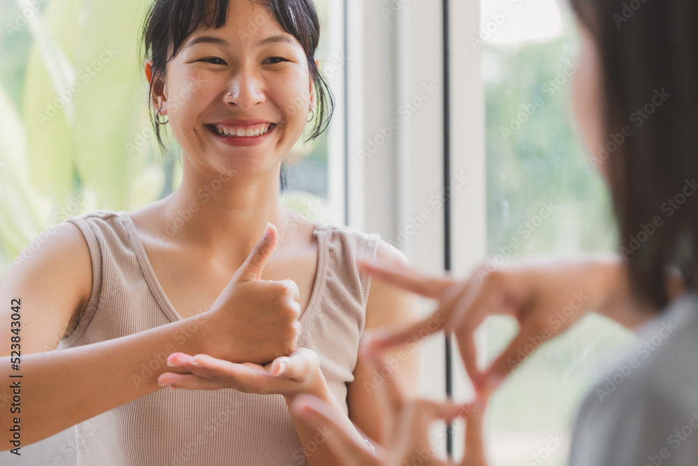 Young attractive Asian women using sign hand finger language ...