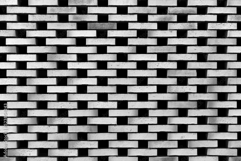 wall of white brick laid in a checkerboard pattern with black gaps ...