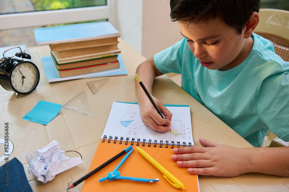 Smart primary school student, school boy doing math and geometry ...