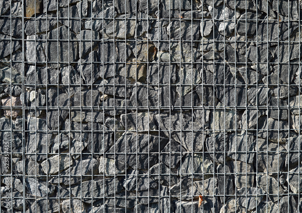 Crushed stones of black color in mesh. Solid image suitable for ...