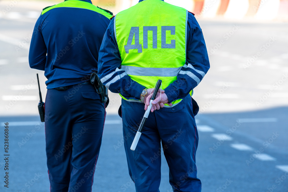 A traffic police officer is on duty at by the road to check drivers ...