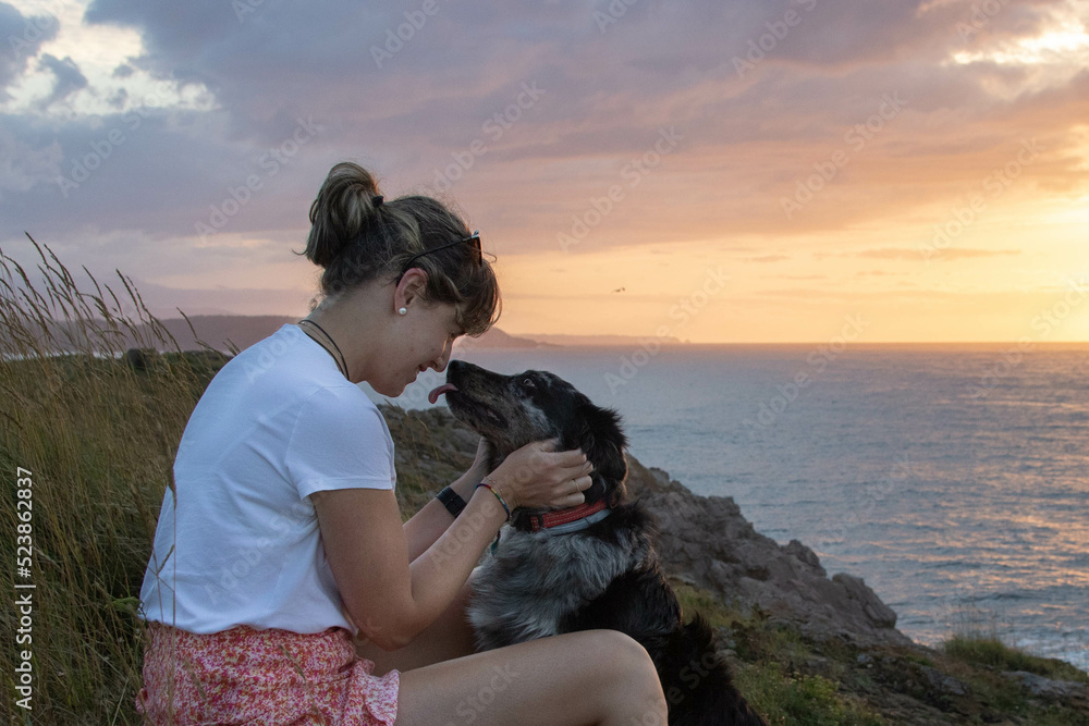 Foto de Perro dándole un beso a su dueña con el mar de fondo do Stock ...