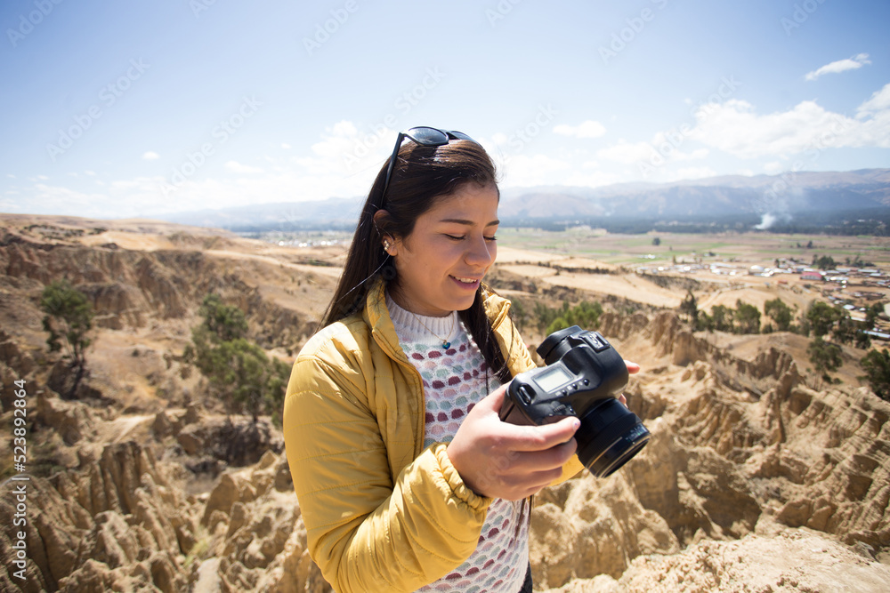 Mujer turista tomando fotos con una cámara profesional en una montaña ...