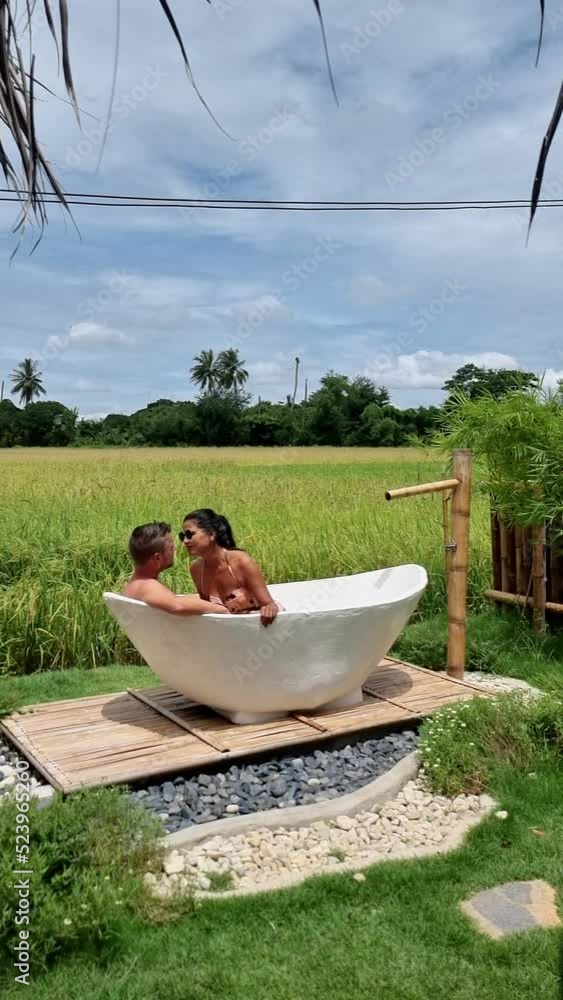 A couple of men and women visiting an eco farm on vacation relaxing in ...