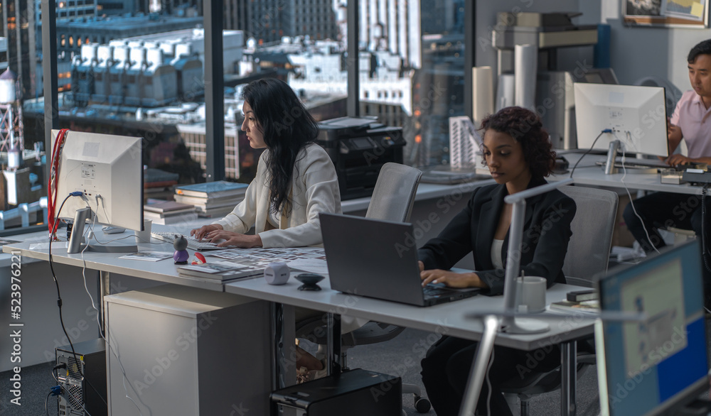 Diverse female employees working at their desks in the office located ...
