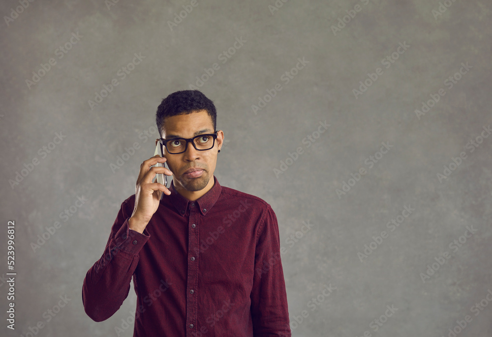 Confused young man making a call to request help at customer support ...