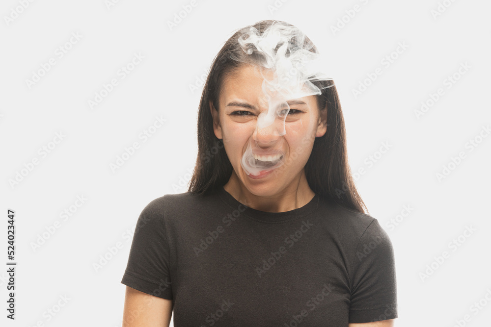 Angry young girl with dark hair releases smoke from the mouth isolated ...