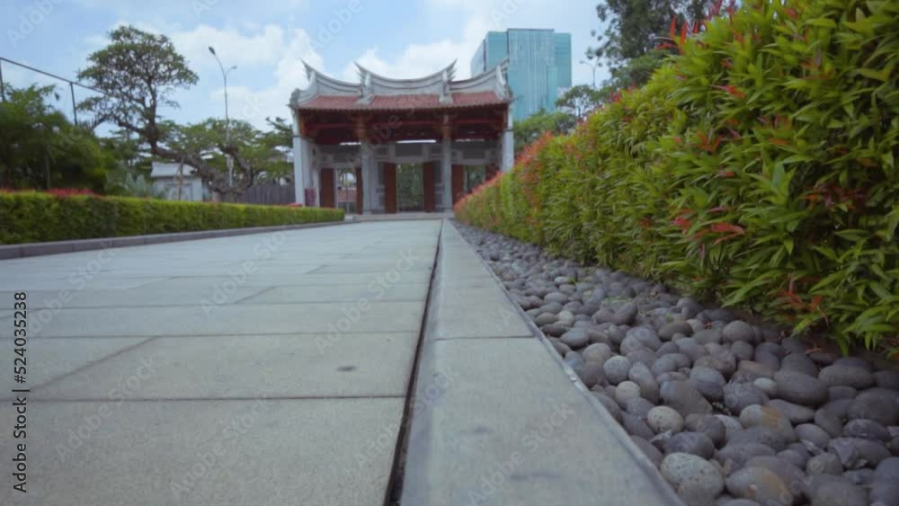 The great Chinese gate wind the grey wall and a red rooftop standing ...