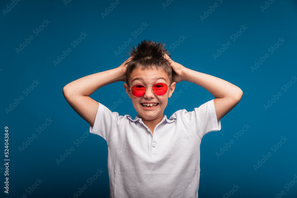 An isolated portrait of an emotional boy. The boy screams with joy and ...