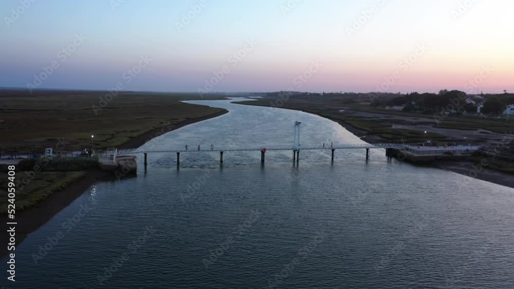 Aerial view of the Trilho do Barril route bridge over Ria Formosa, dusk ...