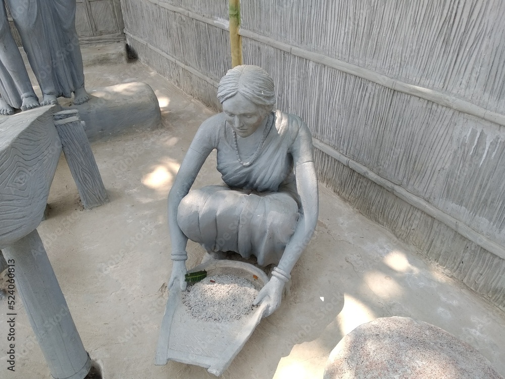A village woman statue processing paddy. Woman sculpture working in a ...