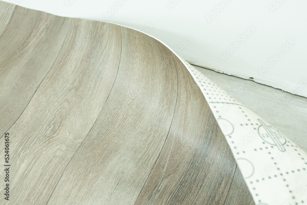 Covering concrete floor with linoleum with wooden structure. Unroling ...