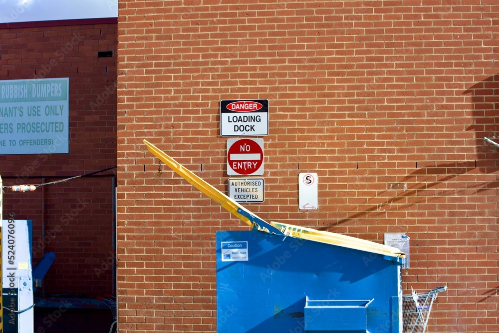Danger loading dock sign and a no entry sign on a brick ball near a ...