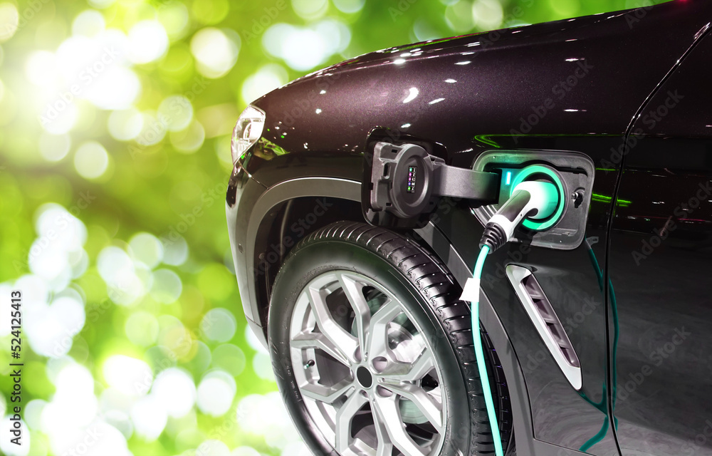 Green energy eco concept. Electric car power cable plugged into car ...