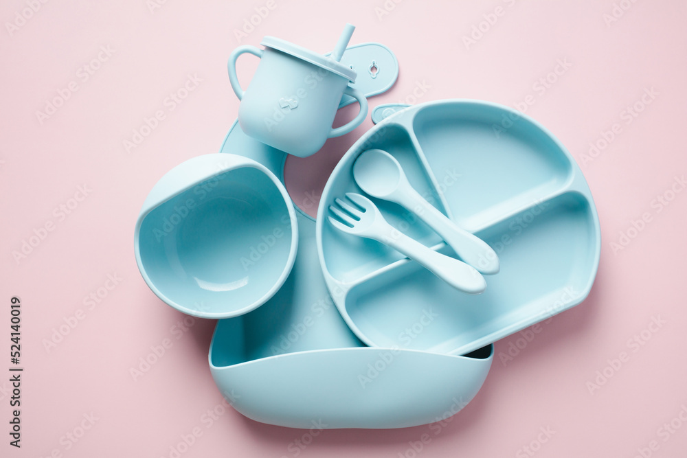 Silicone baby feeding supplies set. Flat lay silicone bib, plate with ...