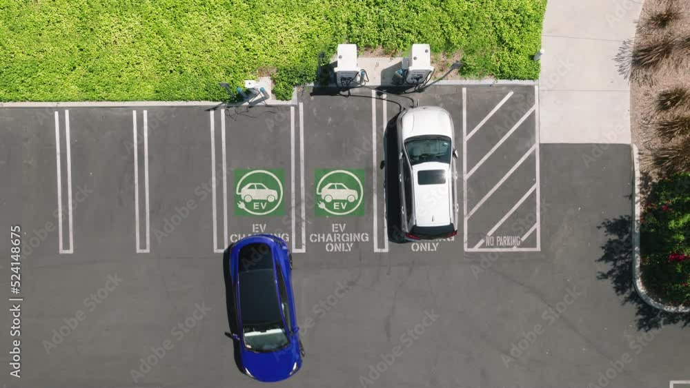 4K aerial overhead view of fully charged blue electric vehicle driving ...