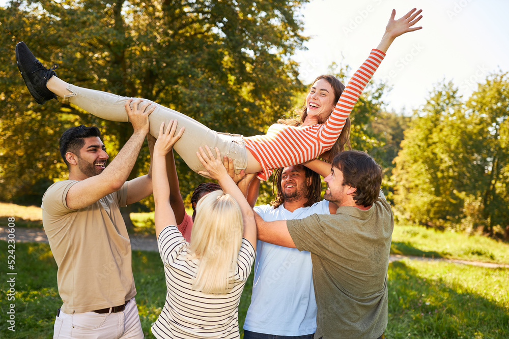 Gruppe junger Leute trägt und hebt eine junge Frau Stock Photo | Adobe ...