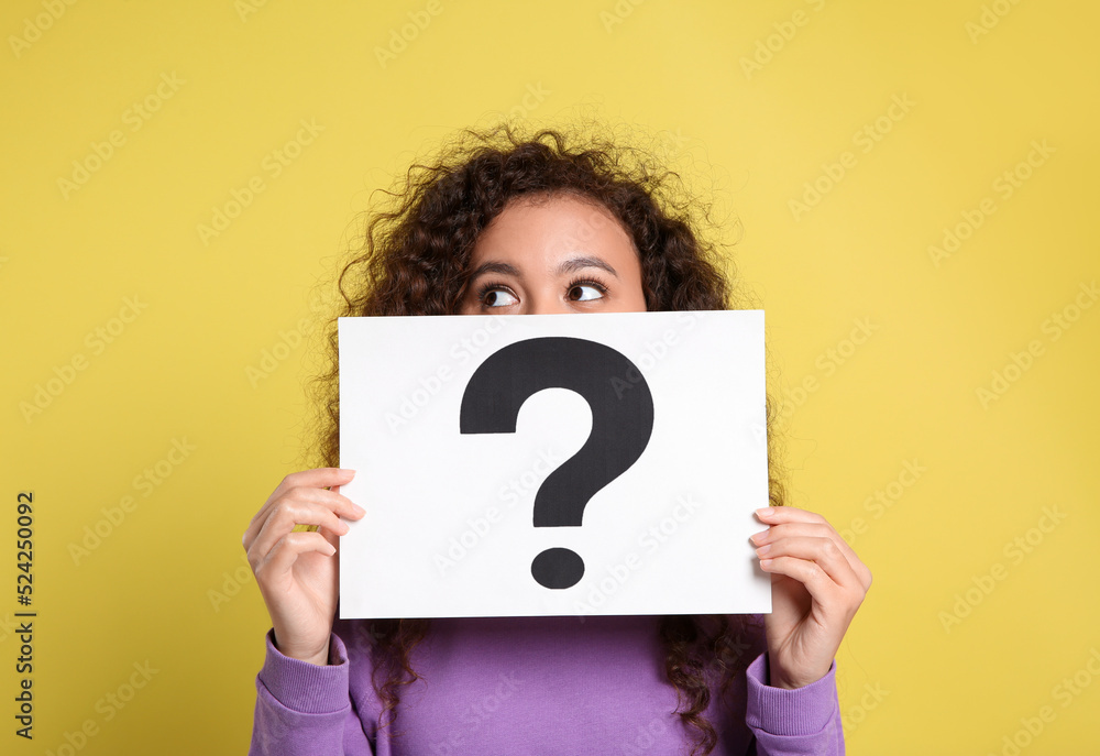 African-American woman with question mark sign on yellow background ...