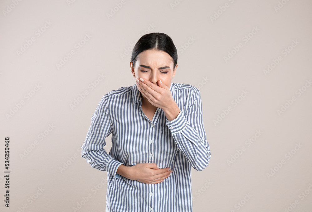 Woman suffering from stomach ache and nausea on beige background. Food ...