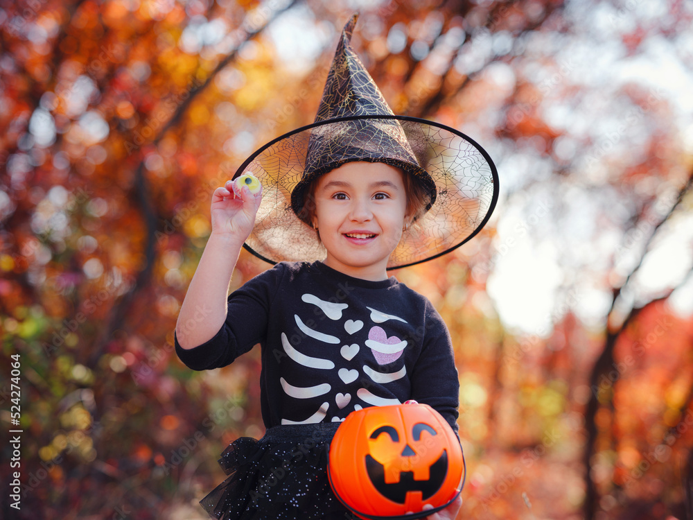 Young girl in black costume goes trick or treating. Little witch, Kids ...