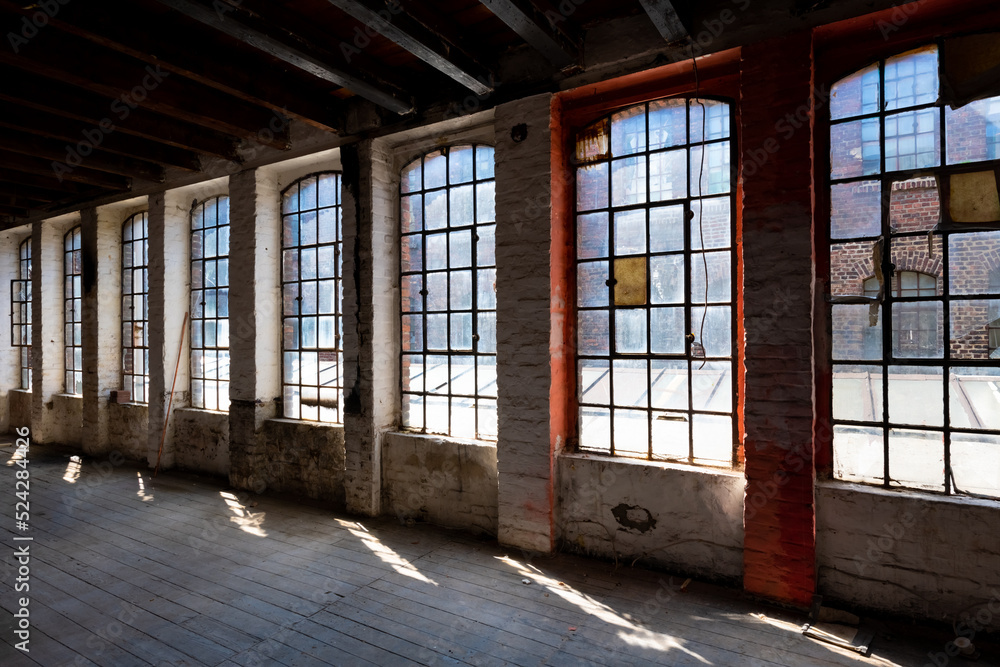 Windows of a ruined factory wall with old and broken mat glass and ...