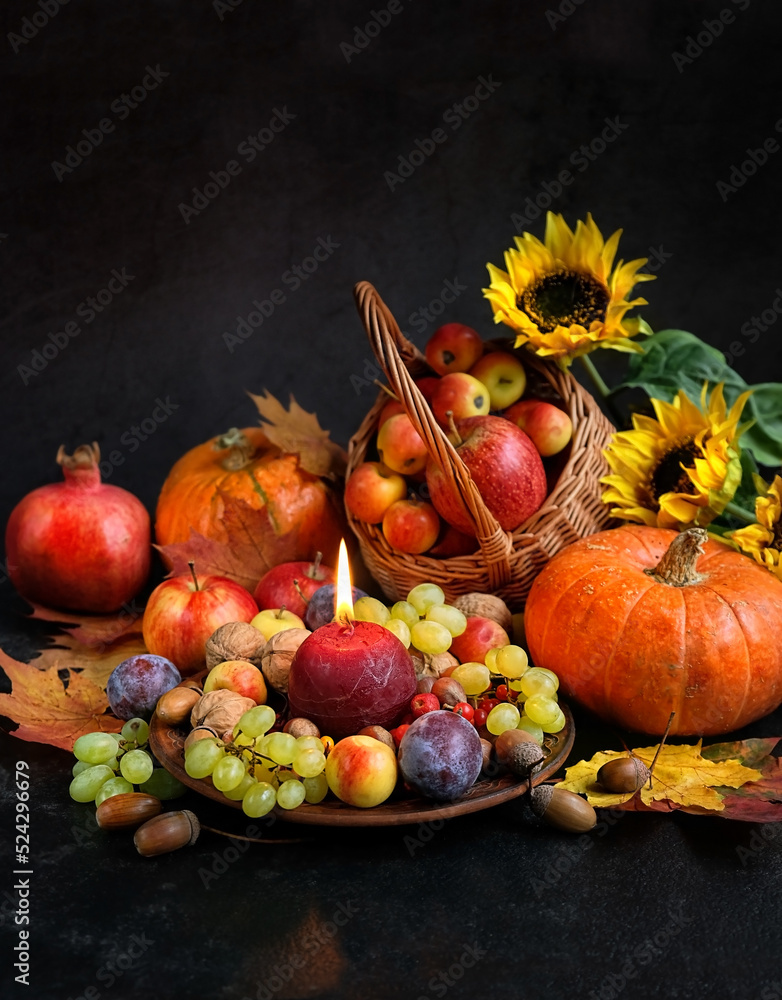 Candle, fresh fruits, pumpkins, flowers on abstract black background ...