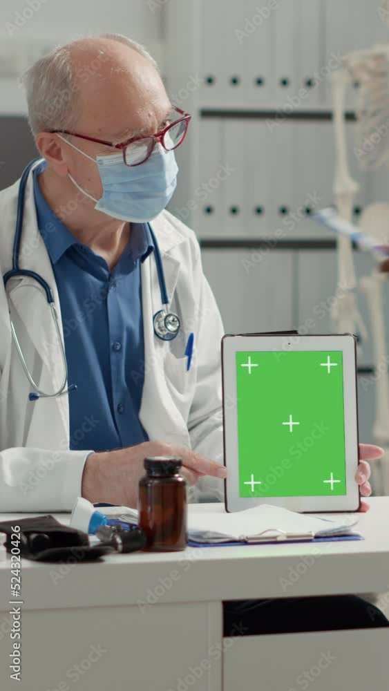Vertical video: Senior medic looking at greenscreen template with ...