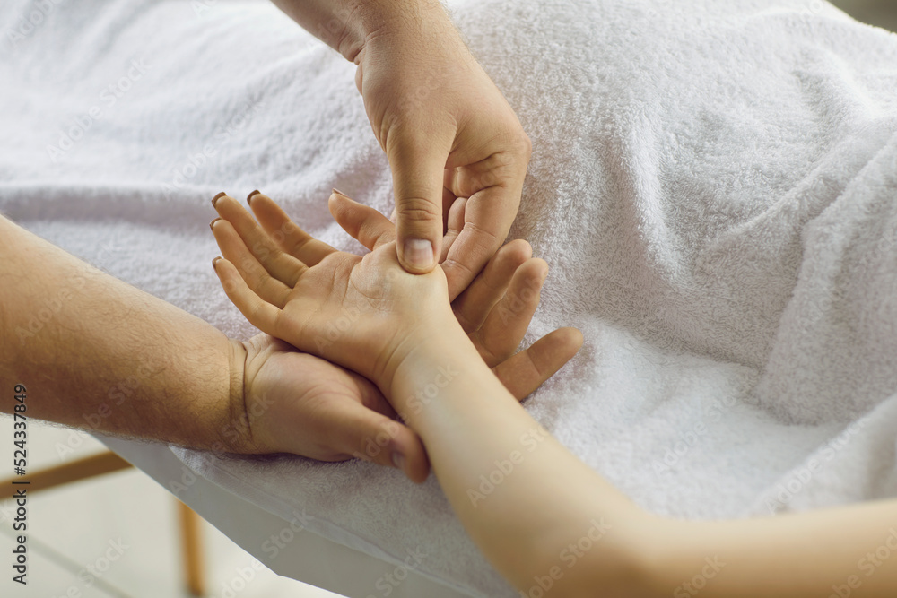 Professional reflexologist doing remedial hand massage to female patient. Reflexology and ...