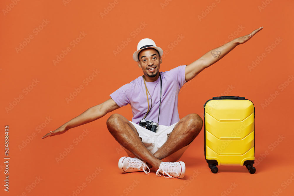 Full body traveler black man in purple tshirt hat spread hands like ...