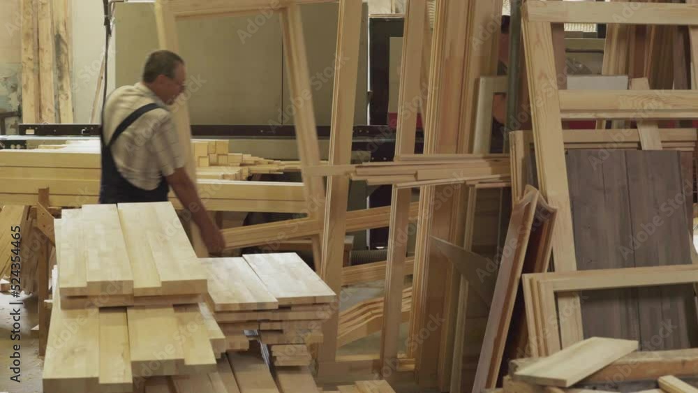 Labourers are carrying the manufactured wood window frames in a ...