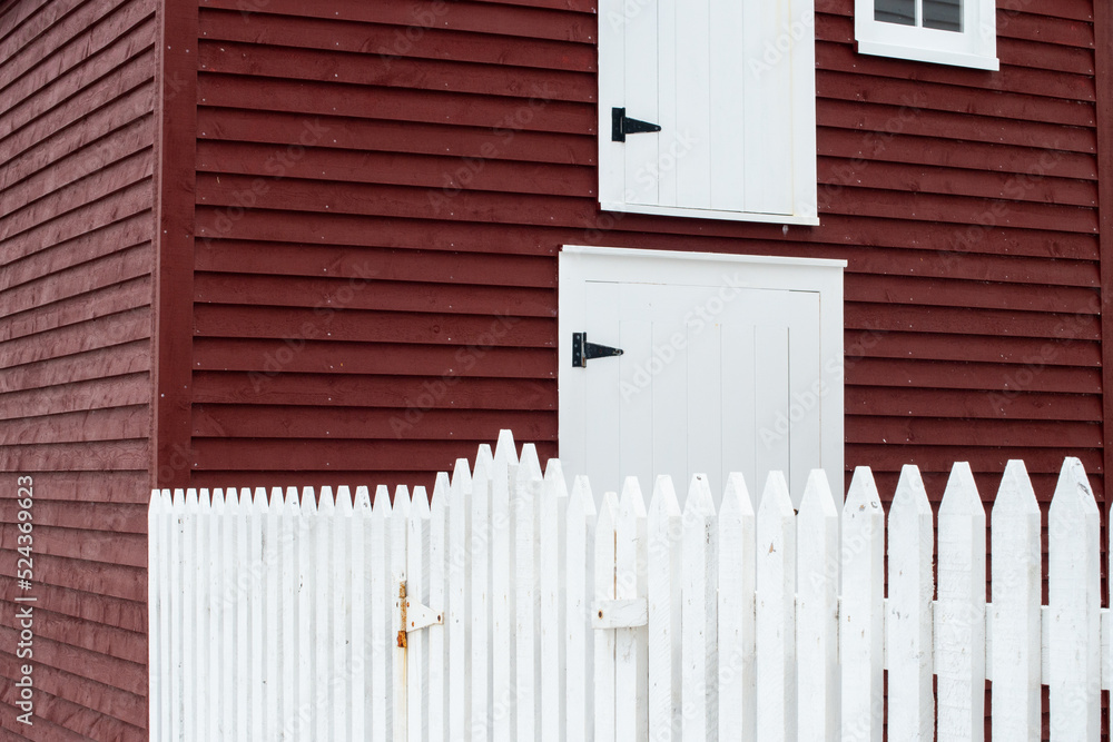 The exterior of a red wooden cape cod clapboard or batten board siding ...