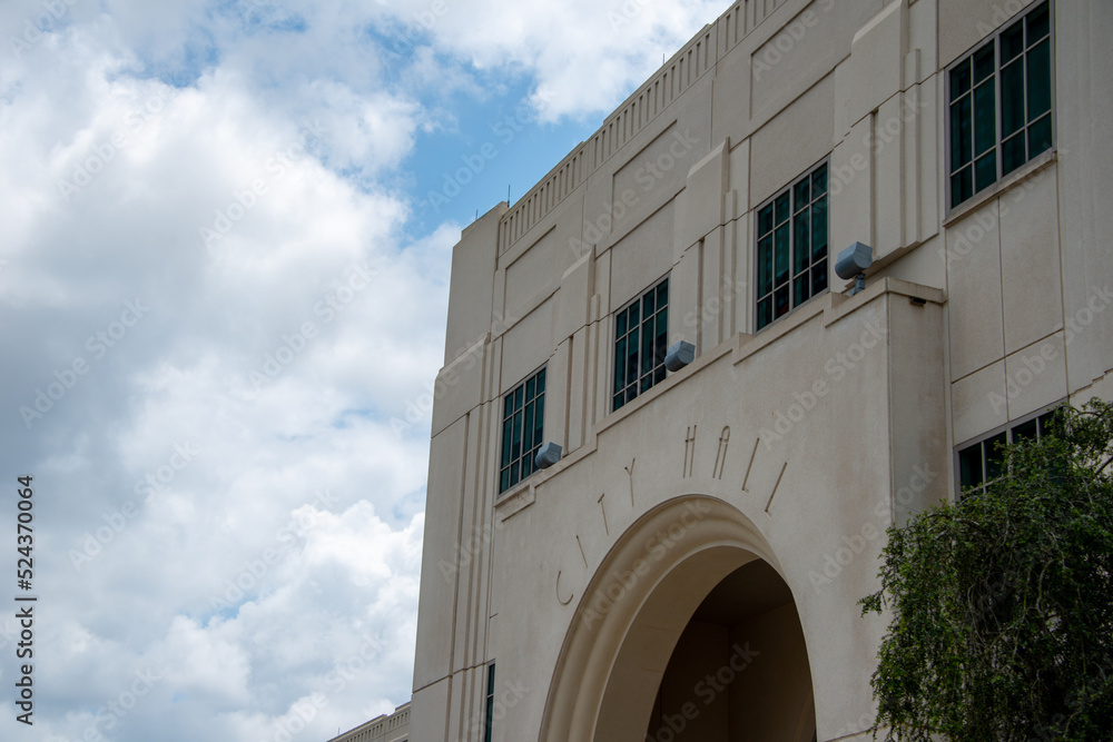 The exterior facade of a vintage city hall building with white ...