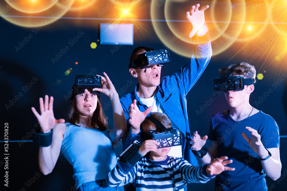 Emotional young parents with two teenage sons having fun with vr ...