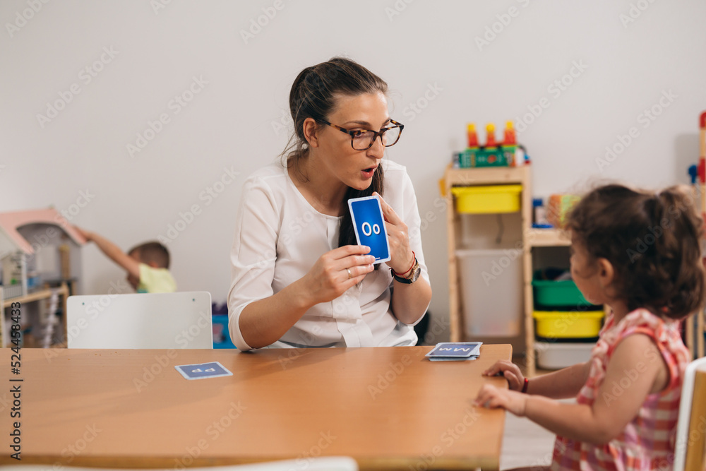 teacher teaching child to correct pronouncing the words at child ...