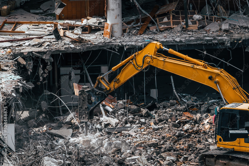Hydraulic crusher excavator backoe machinery working on site demolition ...