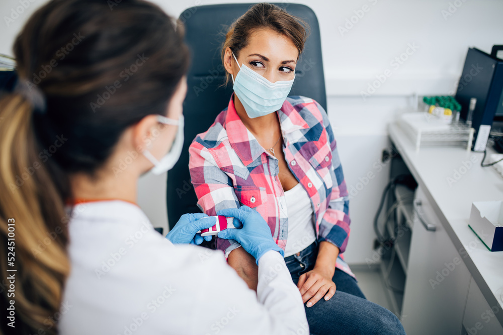 Nurse taking blood sample from young female patient. Stock Photo ...