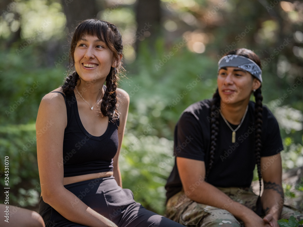 Horizontal image of two young Indigenous friends looking to their right ...