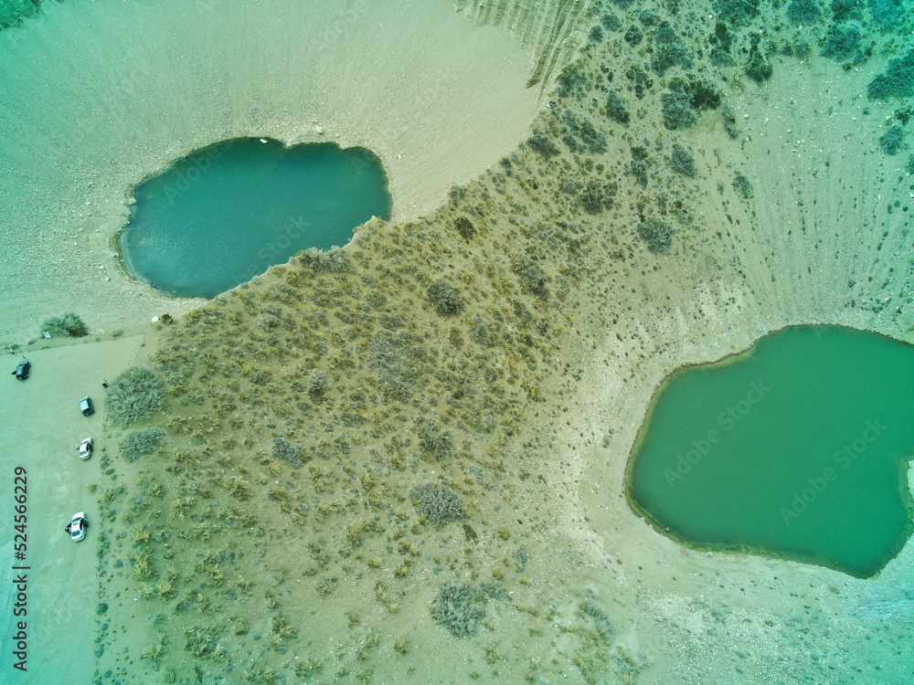 Vista de dos pozos gigante naturales en la tierra, con agua en el fondo ...
