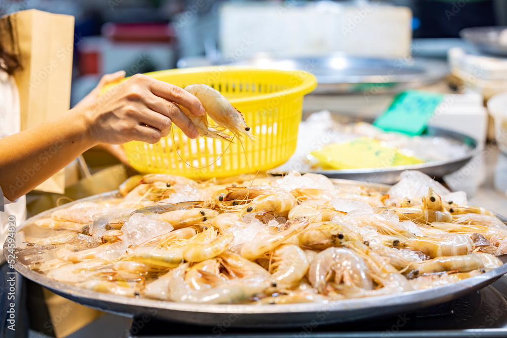 Young woman on seafood department in supermarket or fresh market ...