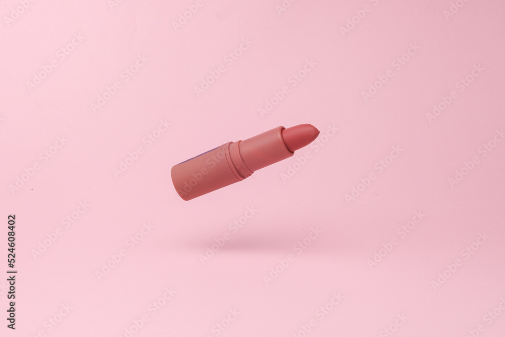 Red lipstick tube flying in antigravity on pink background with shadow ...