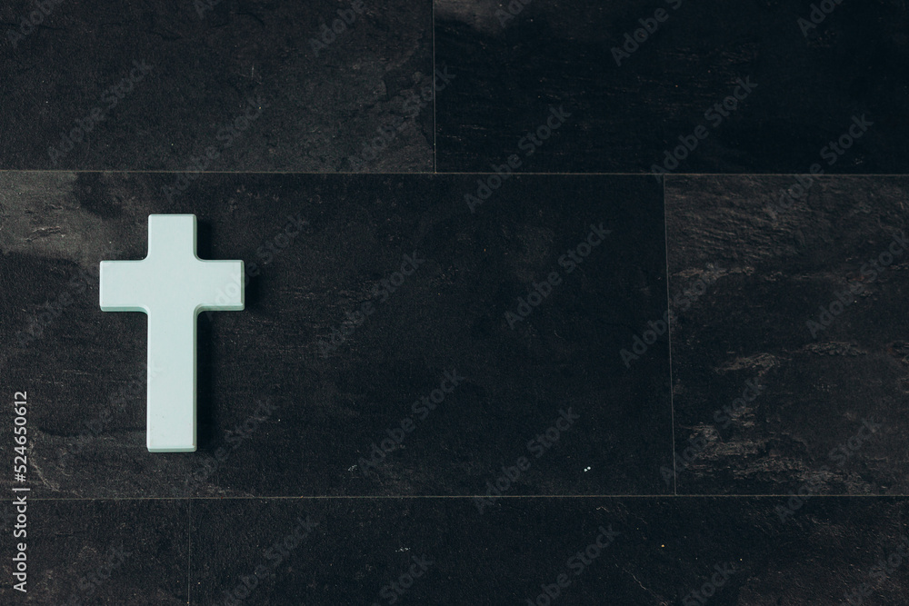 Christian cross on a textured black background. Religion concept. Blue ...