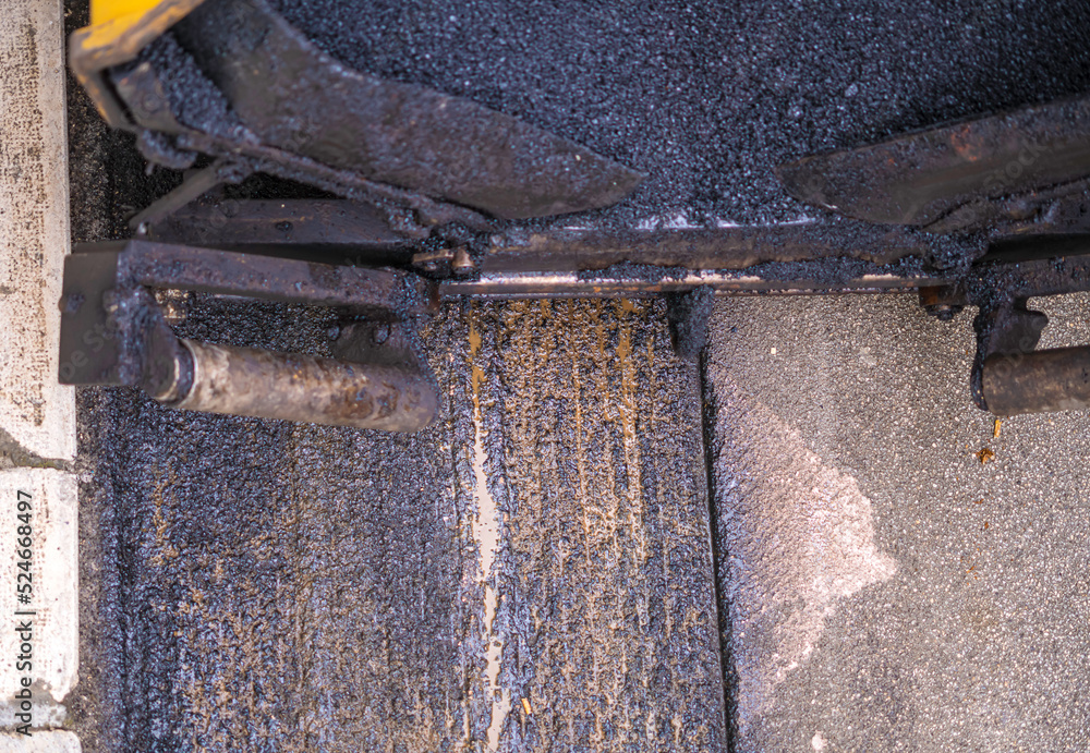 Tracked paver laying fresh asphalt pavement on top of the gravel base ...