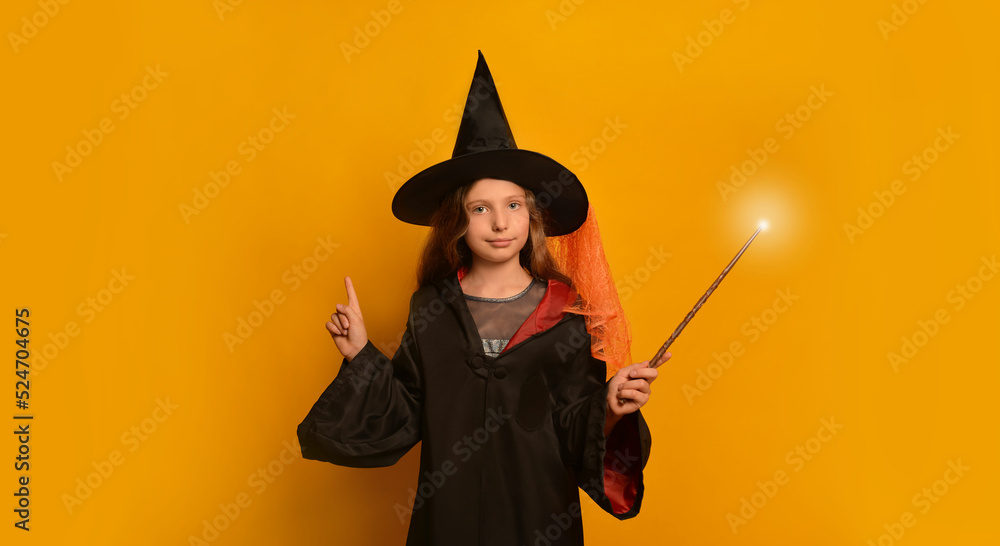 Cute Halloween child girl in wizard costume with luminous magic wand ...