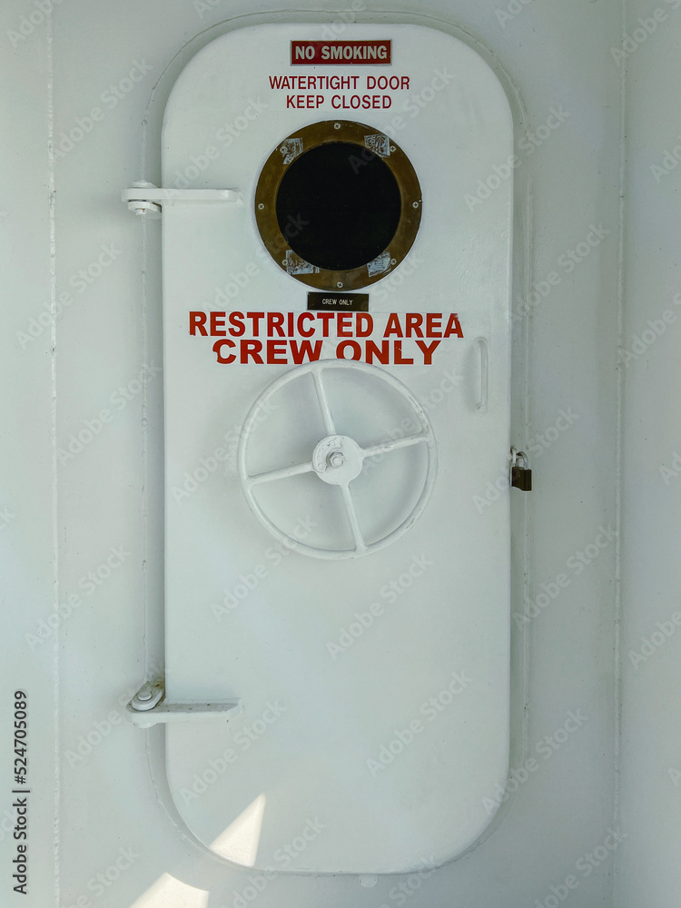 Looking directly at a watertight door on a passenger boat. Sign on door ...