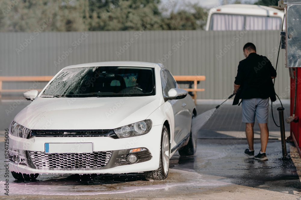 Man washing white car at contactless self-service car wash. Washing ...