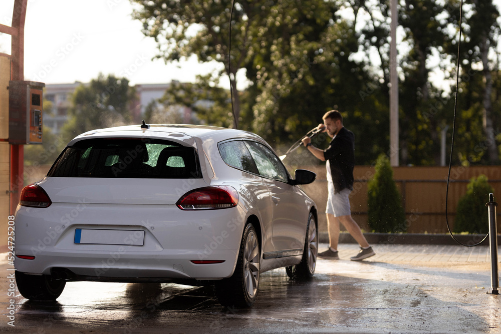 Man washing white car at contactless self-service car wash. Washing ...