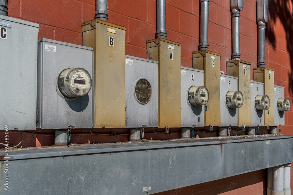 Rusty power meters hanging on a wall with valves during the energy ...